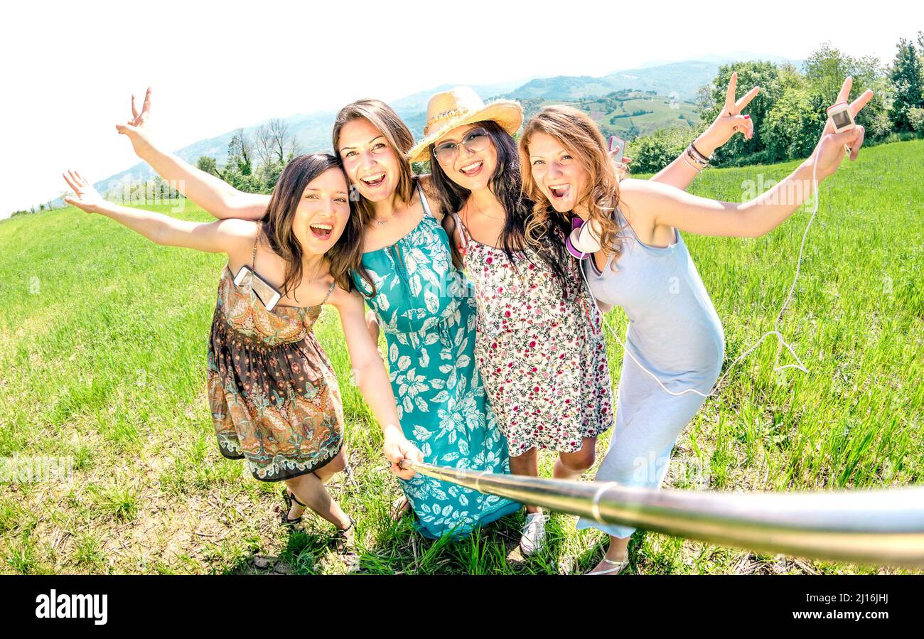 Multiracial girlfriends taking selfie with stick at country picnic ...