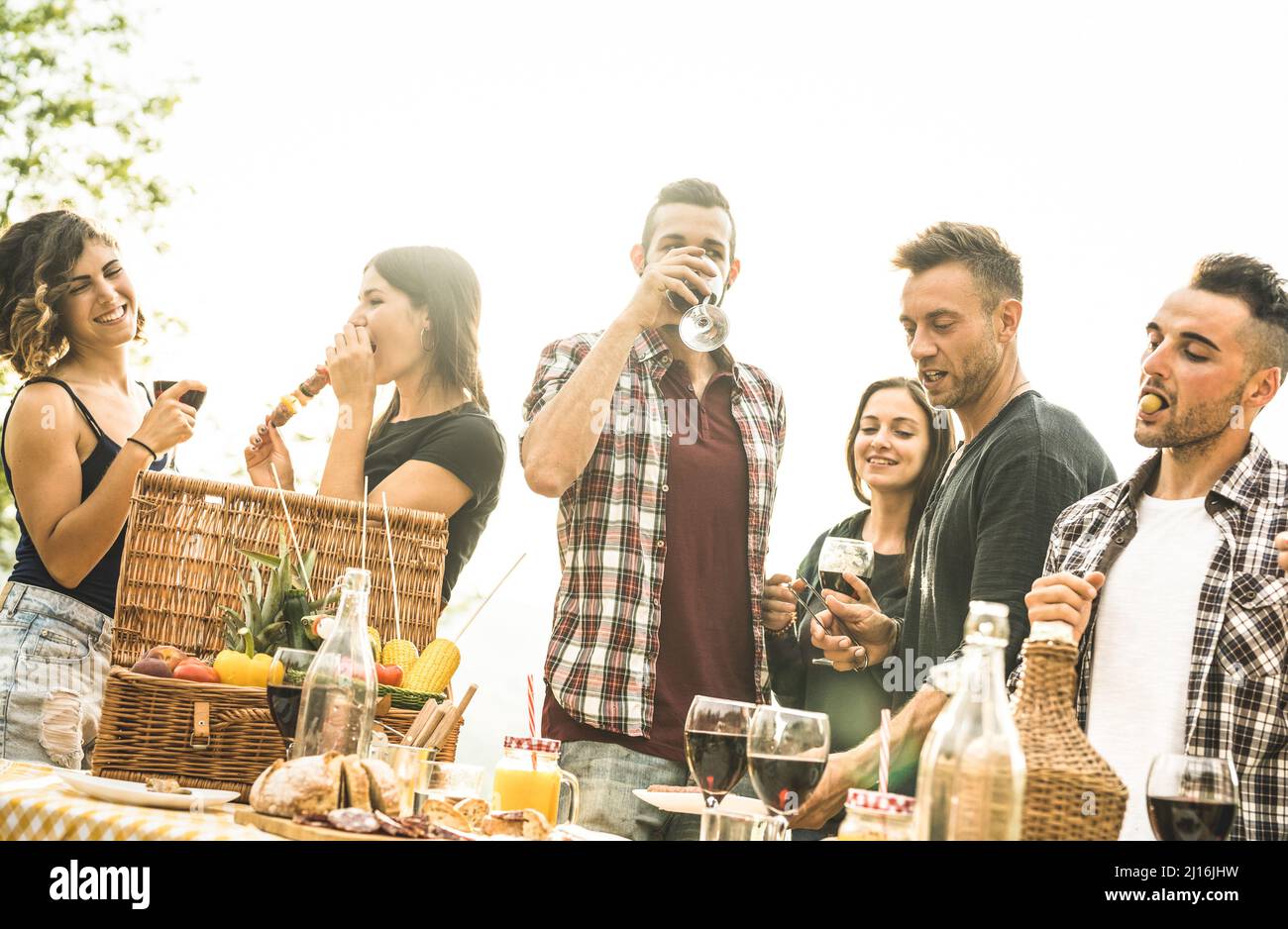 Young friends having fun outdoors drinking red wine and talking at ...