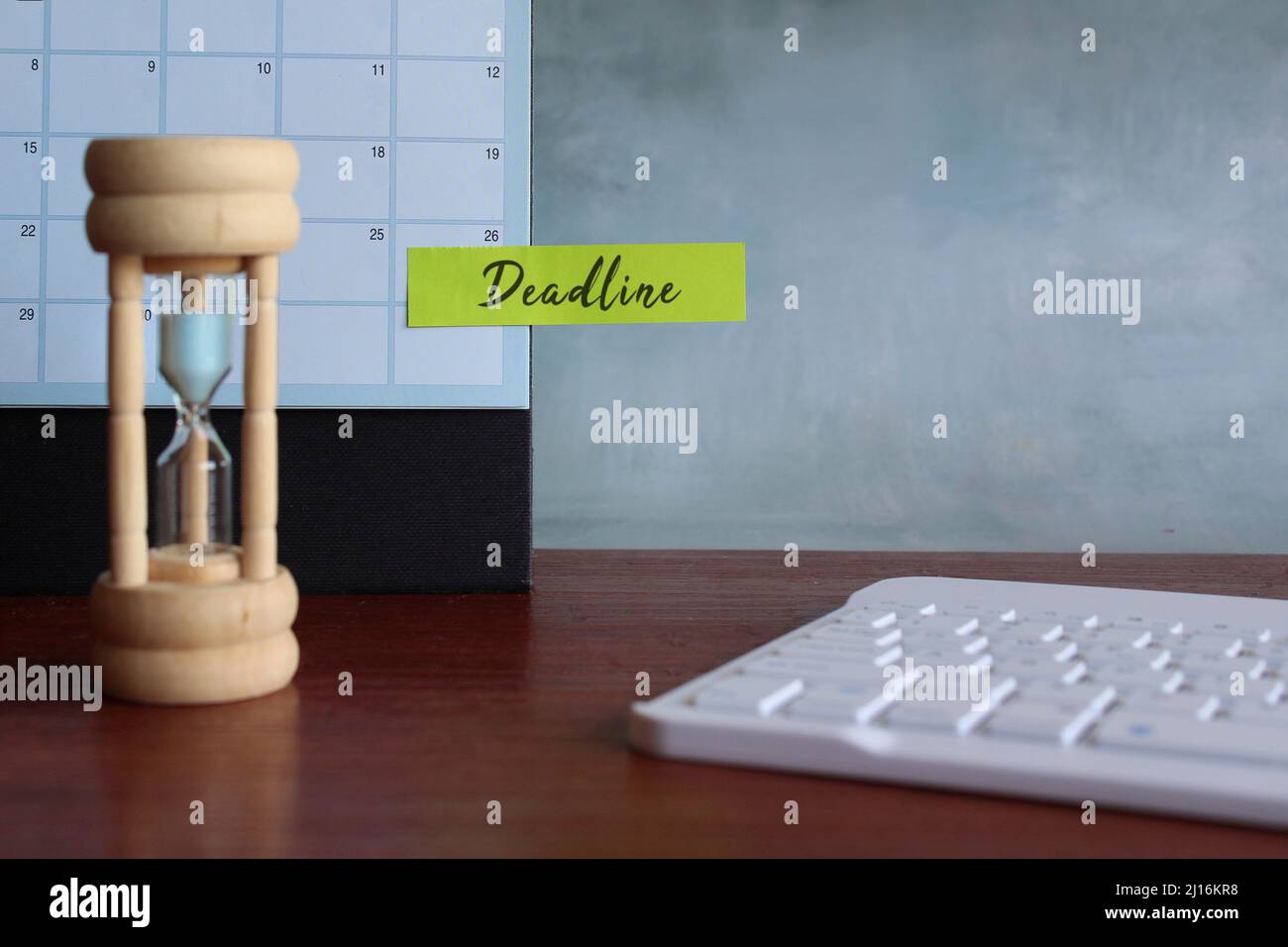 Keyboard, sandglass and calendar with note DEADLINE. Deadline in work ...