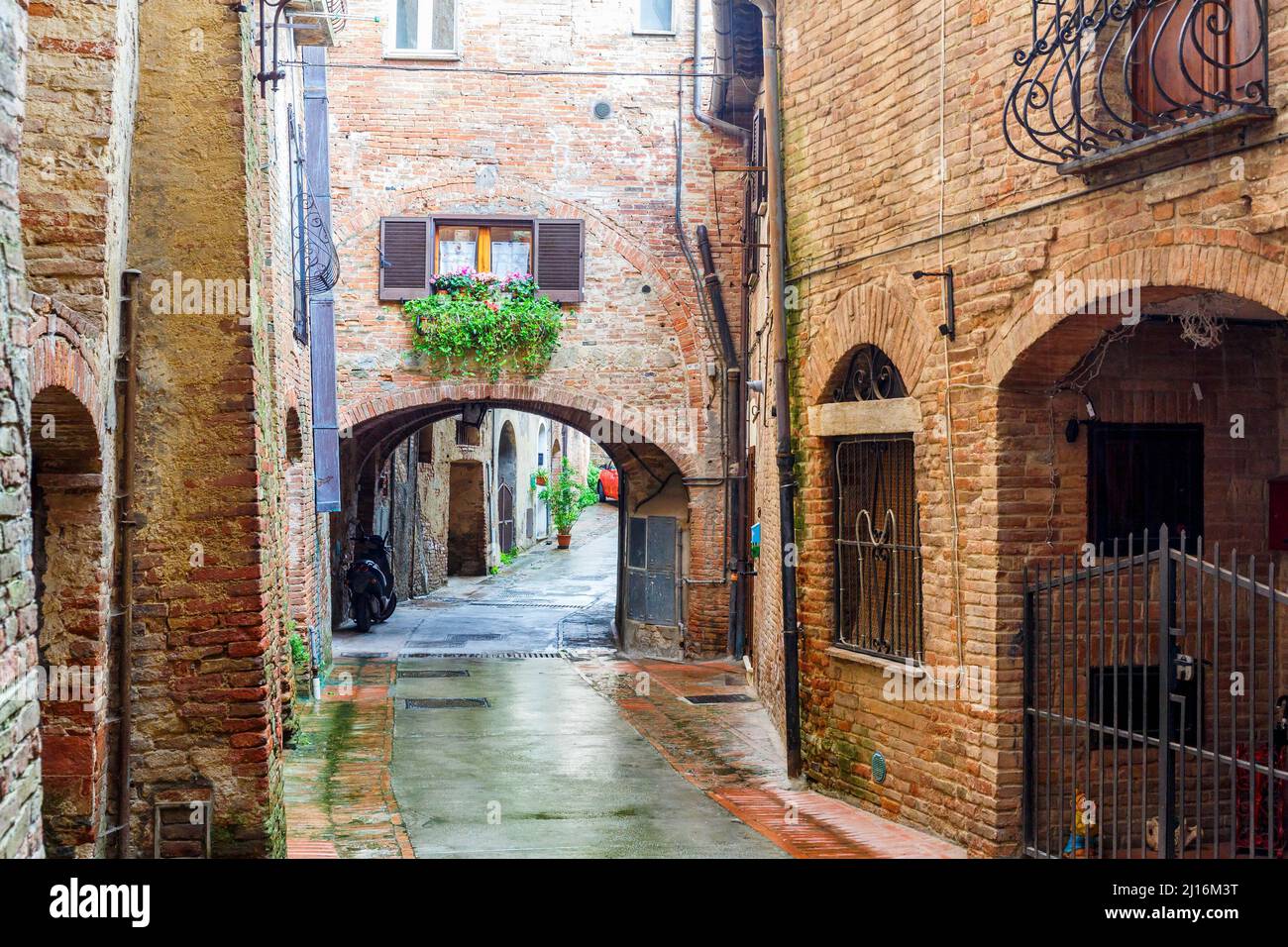 Back street in an old Italian town with iron gate Stock Photo - Alamy