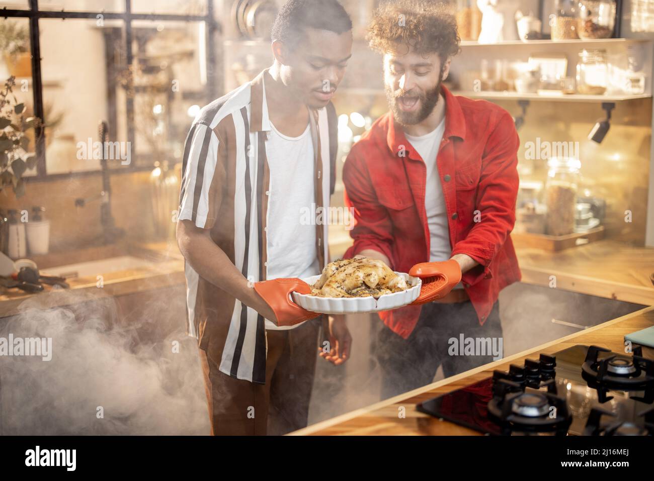 Two guys with cooked meal together on kitchen Stock Photo - Alamy