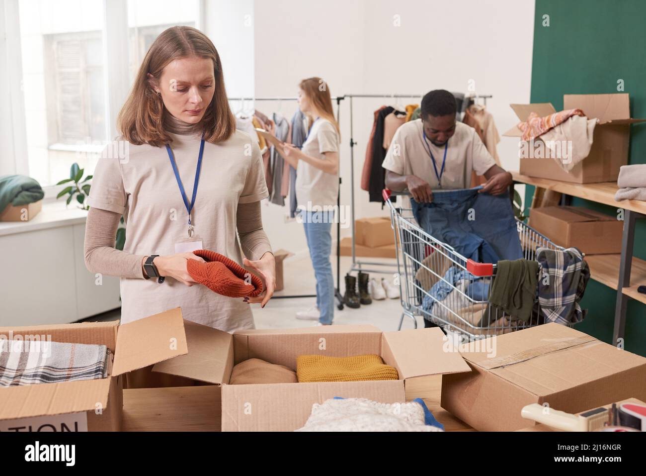Group of multi-ethnic people working together in clothes charity ... Group of multi-ethnic people working together in clothes charity ...