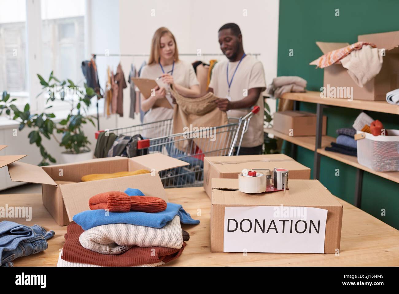 Woman sorting clothes for charity hi-res stock photography and images ...