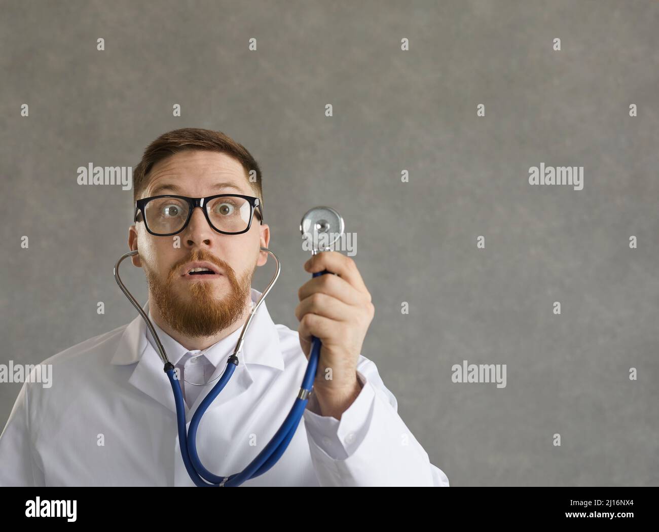 Shocked female doctor with a surprised face raises a stethoscope ...