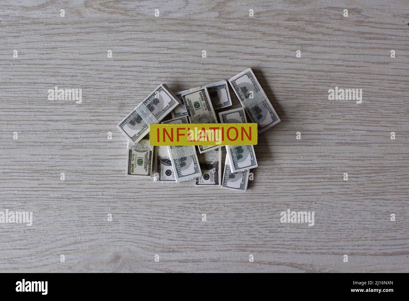 Top view image of banknotes and wooden tile with text INFLATION ...