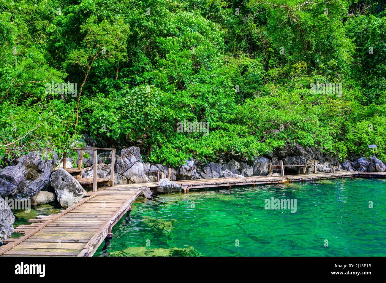 Kayangan Lake - Blue crystal water in paradise lagoon - walkway on wooden pier in tropical ...