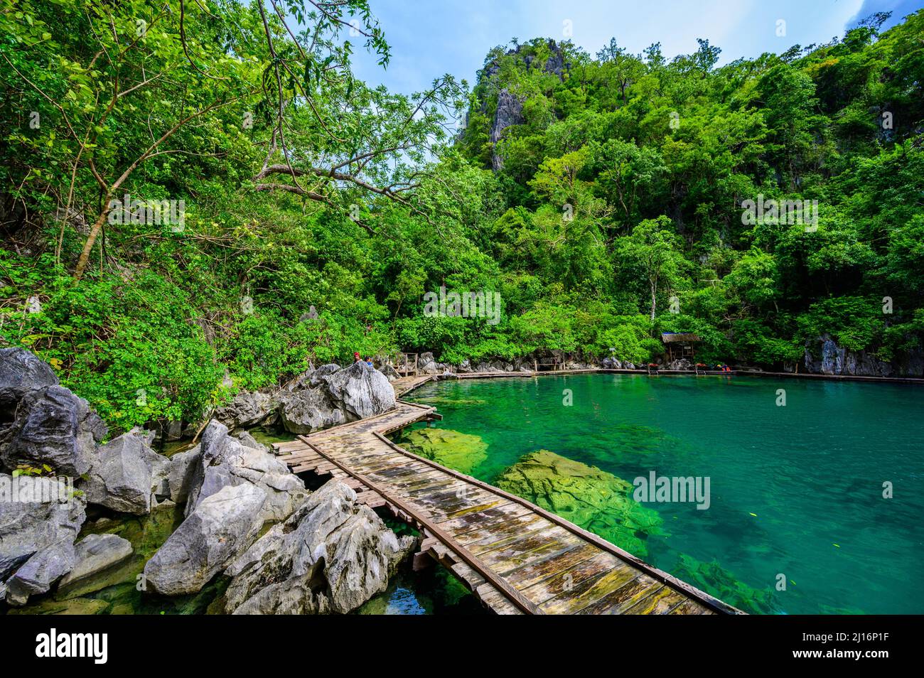 Kayangan Lake - Blue crystal water in paradise lagoon - walkway on wooden pier in tropical ...