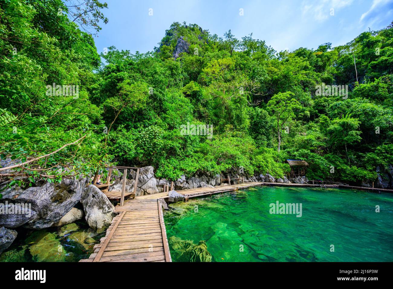 Kayangan Lake - Blue crystal water in paradise lagoon - walkway on wooden pier in tropical ...