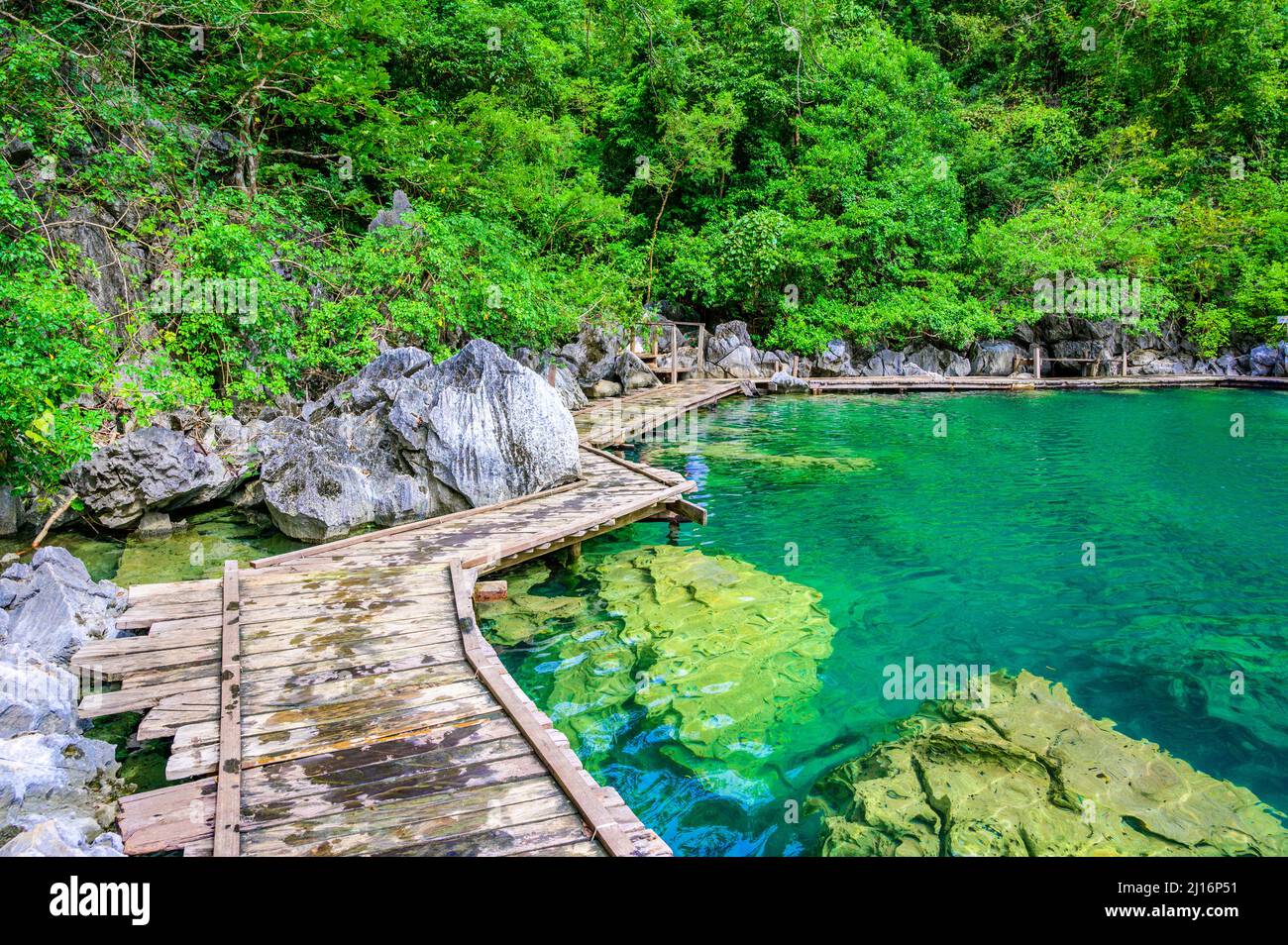 Kayangan Lake - Blue crystal water in paradise lagoon - walkway on wooden pier in tropical ...