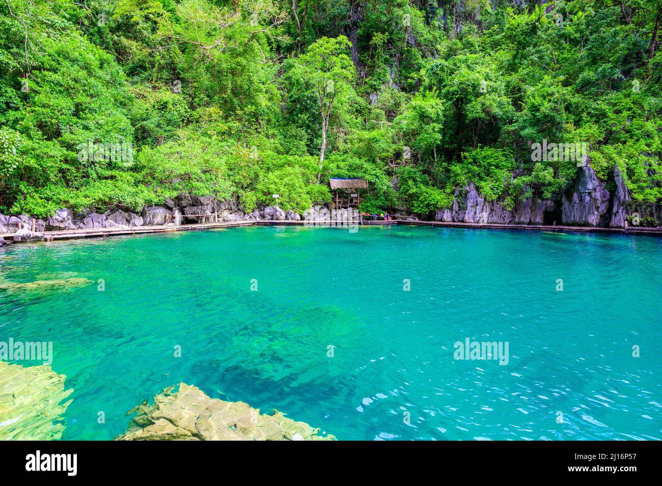 Kayangan Lake - Blue crystal water in paradise lagoon - walkway on wooden pier in tropical ...