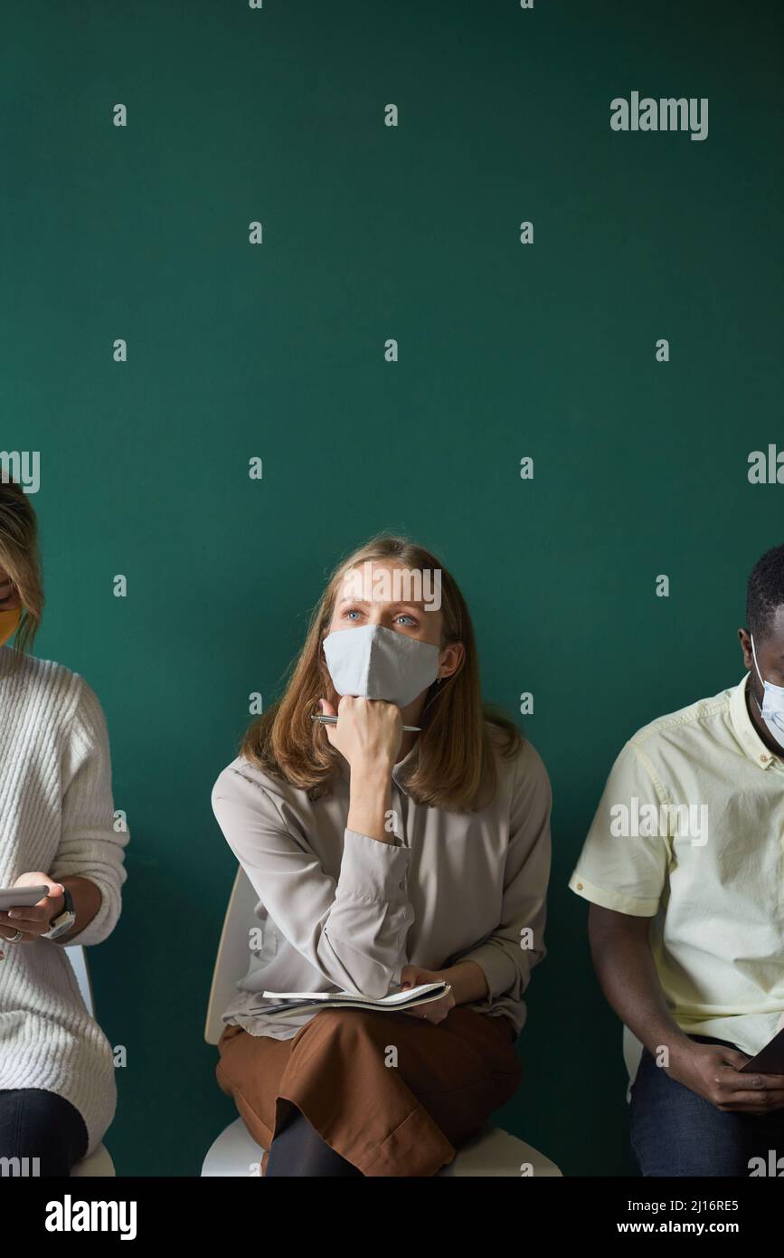 Unrecognizable Caucasian woman sitting against tidewater green wall ...