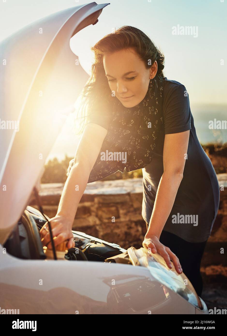 She might have to get some roadside assistance. Cropped shot of a young ...