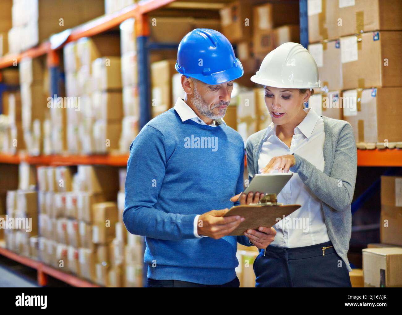 Comparing notes for accuracy. Shot of two people doing an inventory ...