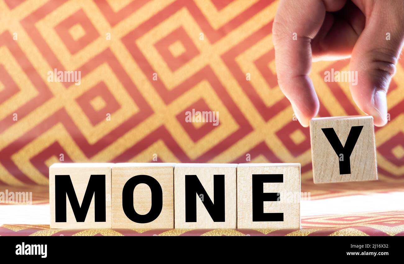 Word MONEY is made of wooden building blocks lying on the table and on ...
