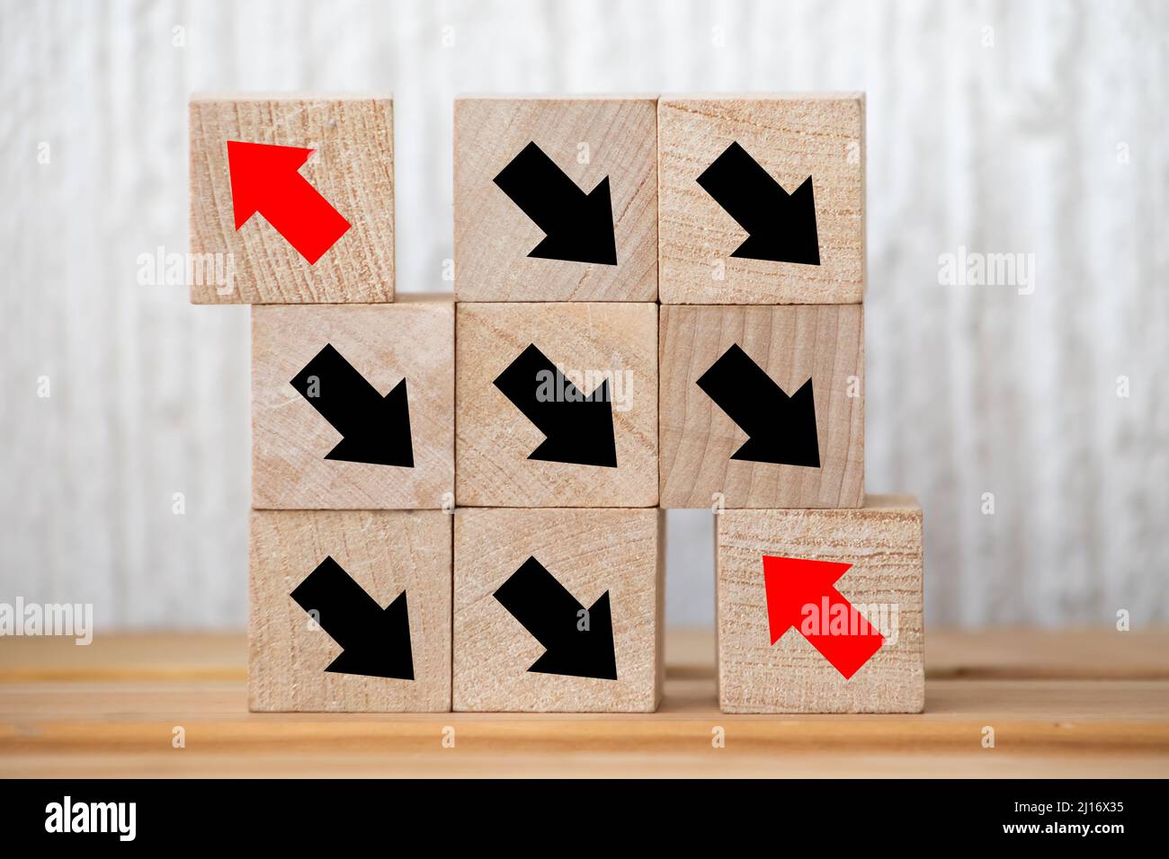 Wooden block with red arrow facing the opposite direction black arrows ...