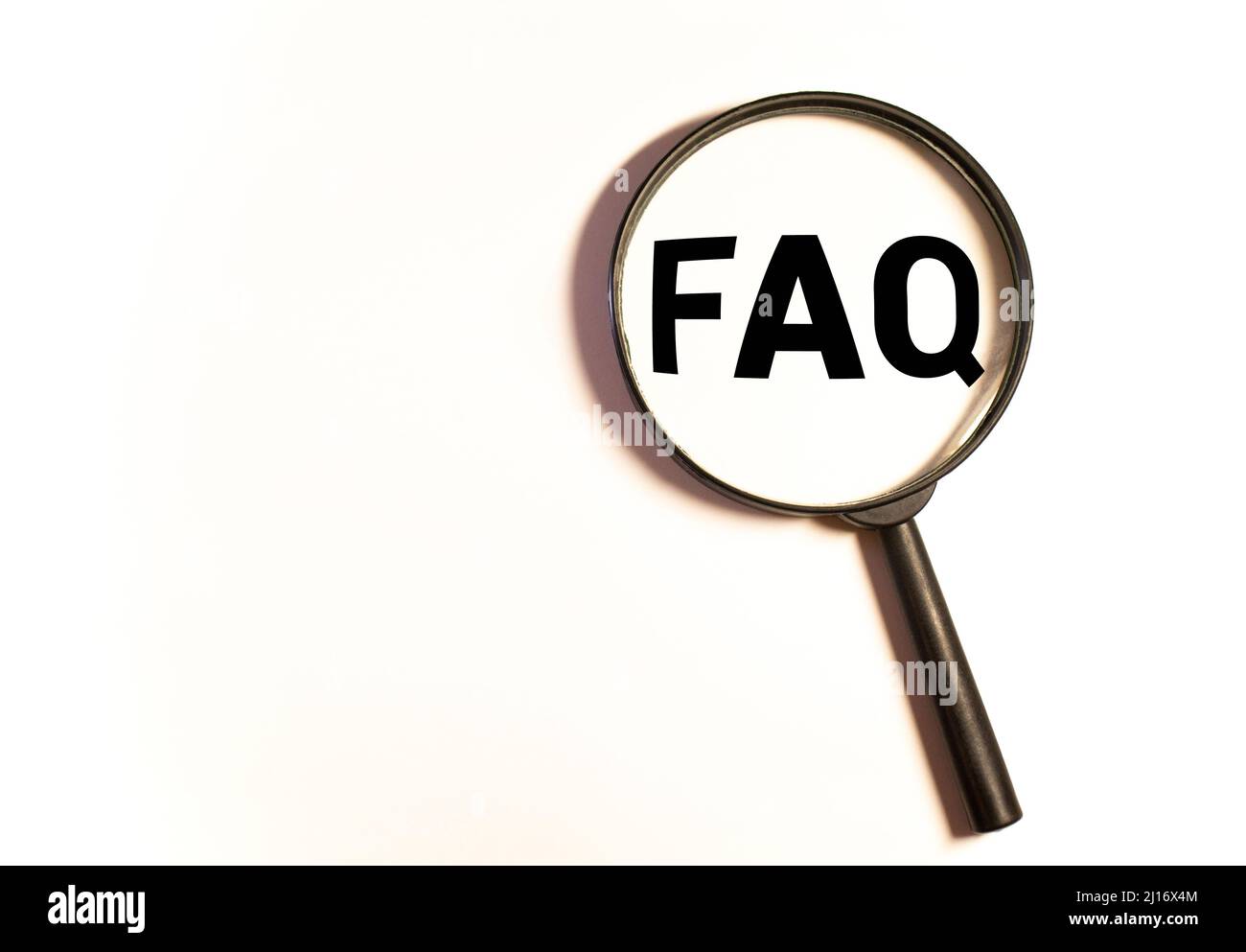 Magnifying glass on wood letters as FAQ abbreviation, frequently asked questions on wooden ...