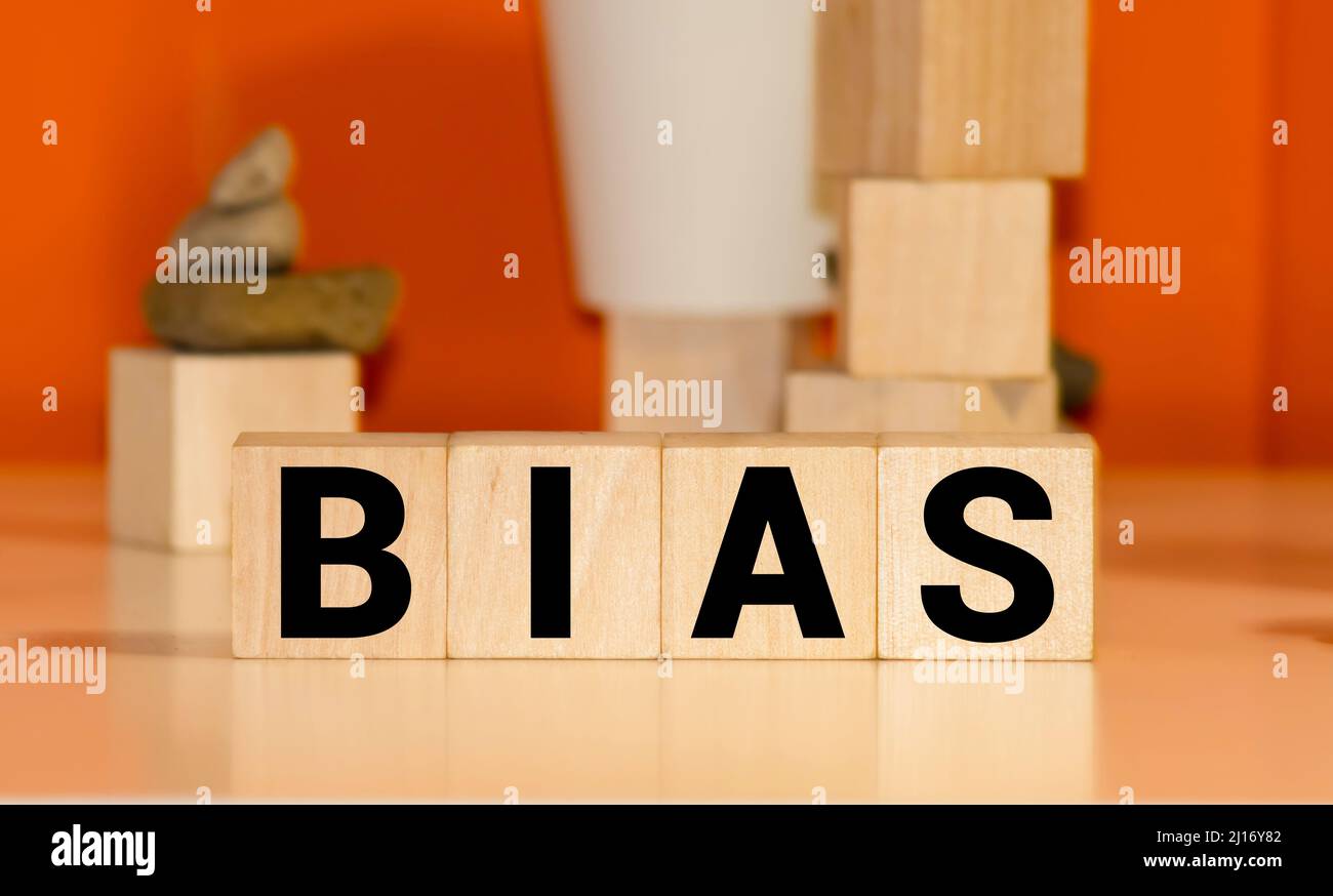 The word BIAS, spelt with wooden letter tiles over a white background ...
