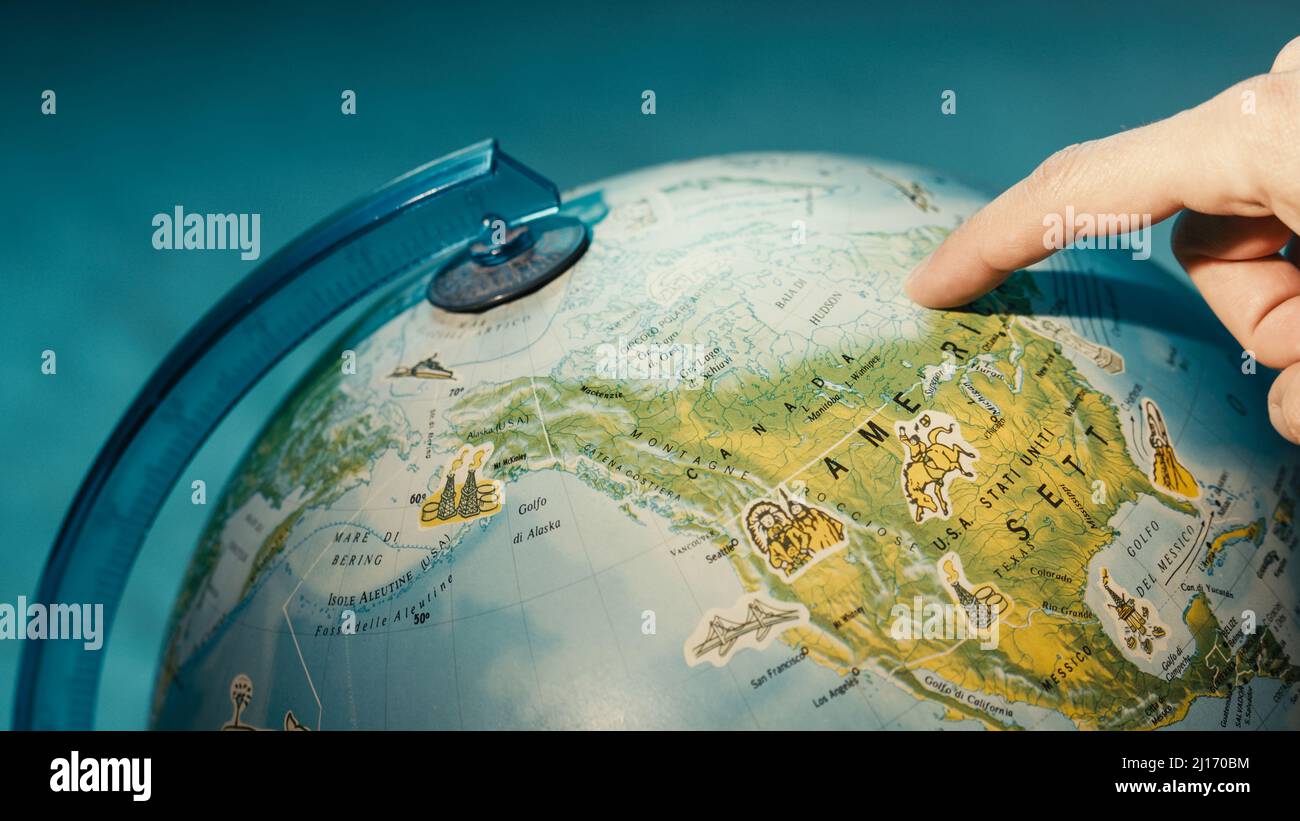 Close up of finger pointing on globe Stock Photo - Alamy