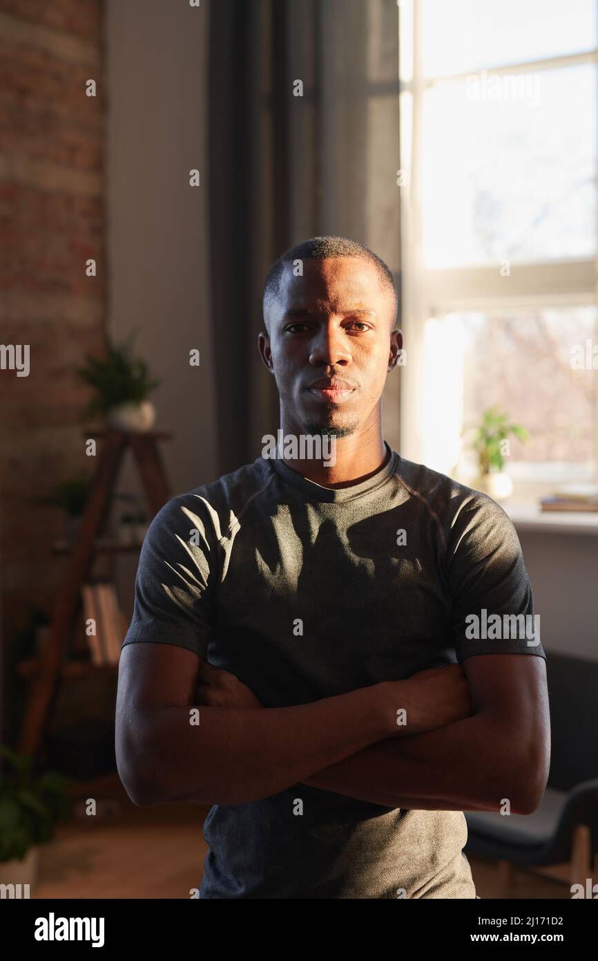 Vertical medium portrait of confident young Black man standing with ...