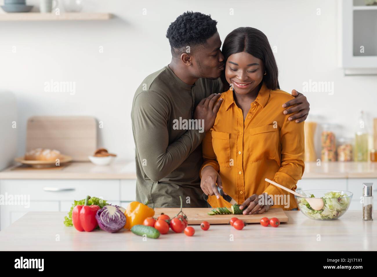 Loving Black Husband Kissing Wife While She Cooking Food In Kitchen ...