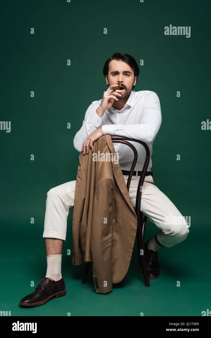 Handsome young man sitting smoking hi-res stock photography and images ...