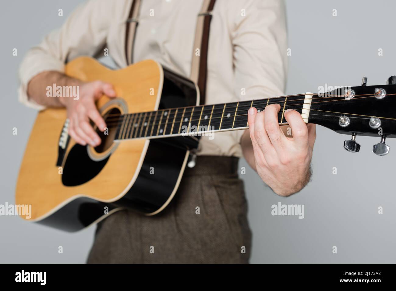 partial view of man retro style clothing playing acoustic guitar ...
