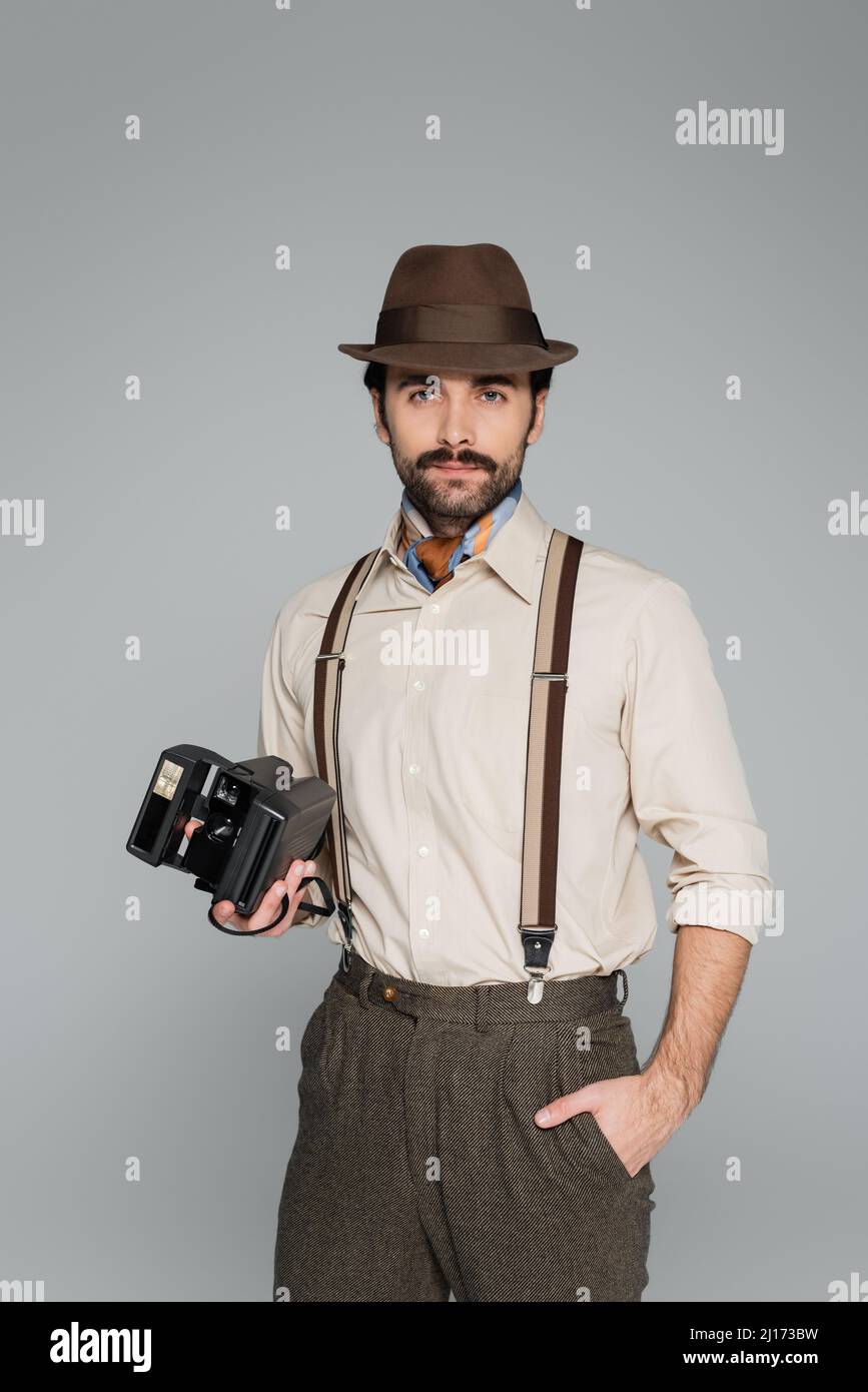 man retro style clothing and hat holding vintage camera and standing ...