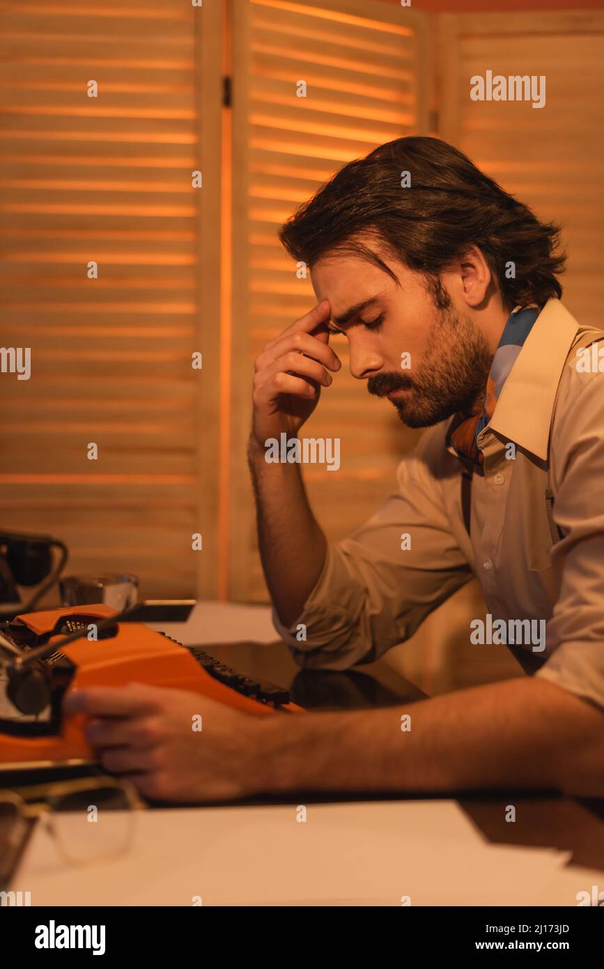 side view of pensive writer thinking near typewriter machine Stock ...