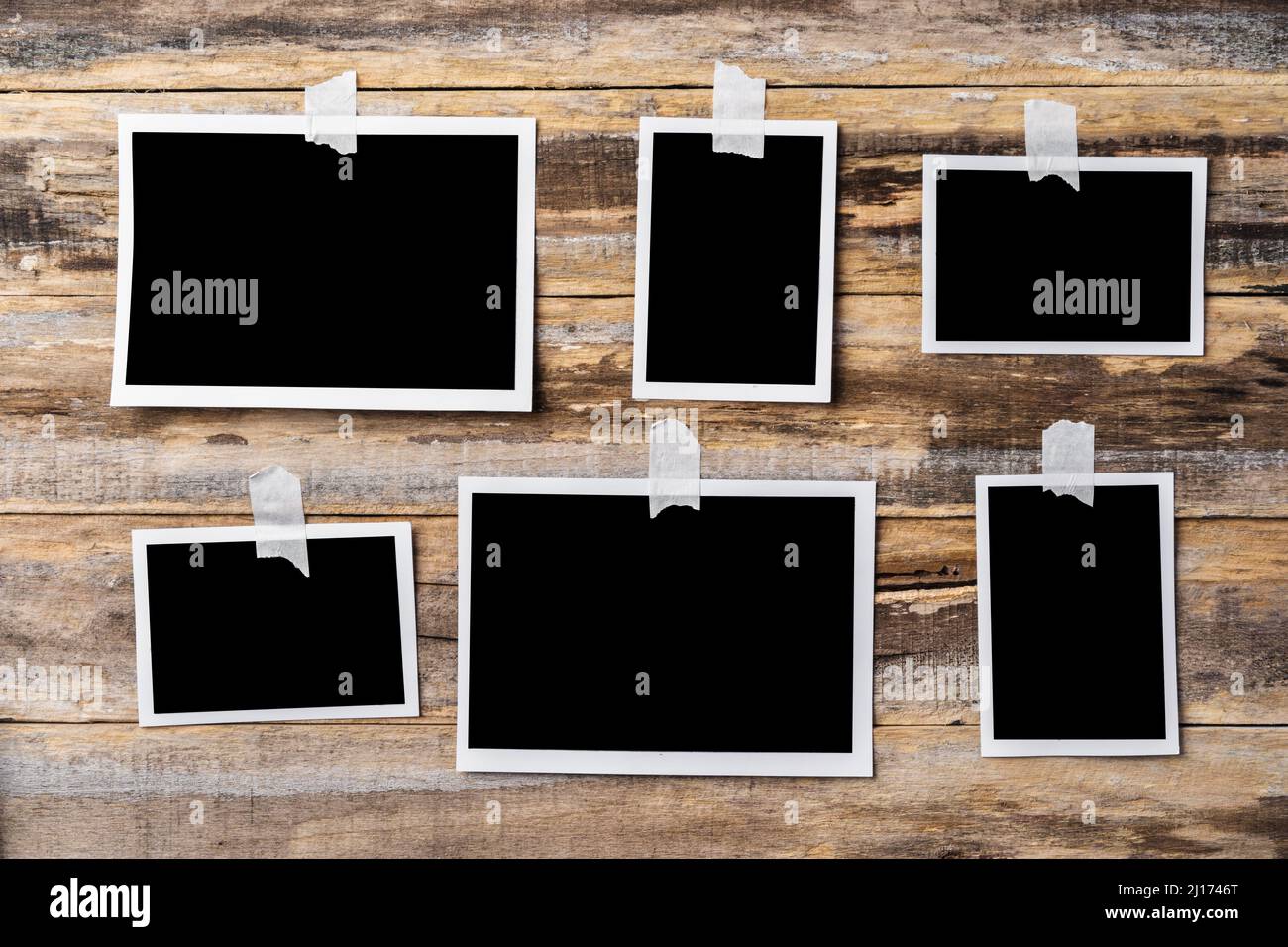 Paper blank photo frames hanging on wooden wall Stock Photo - Alamy