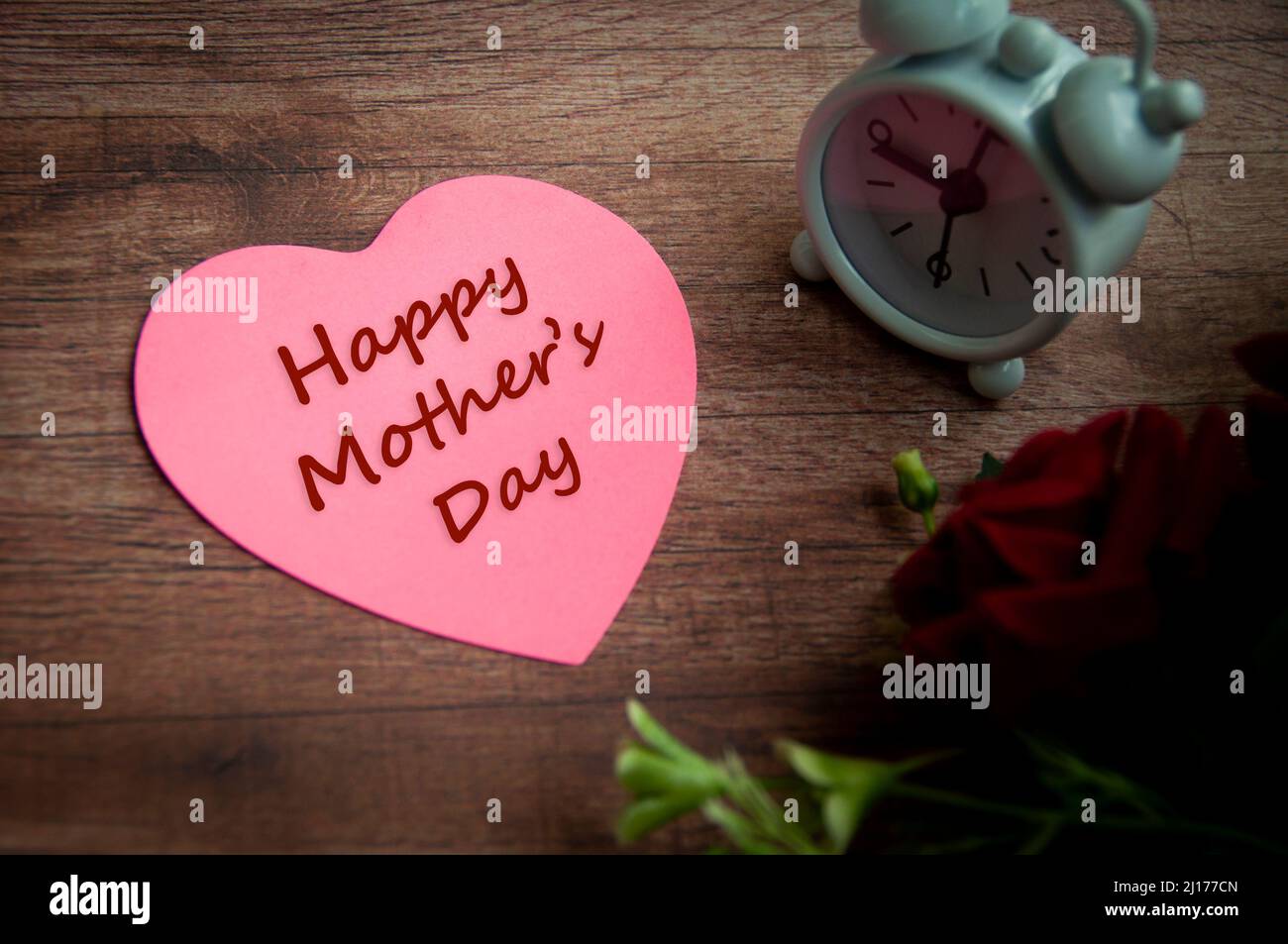 Happy mother's day text on heart shape sticky note. Roses and clock ...