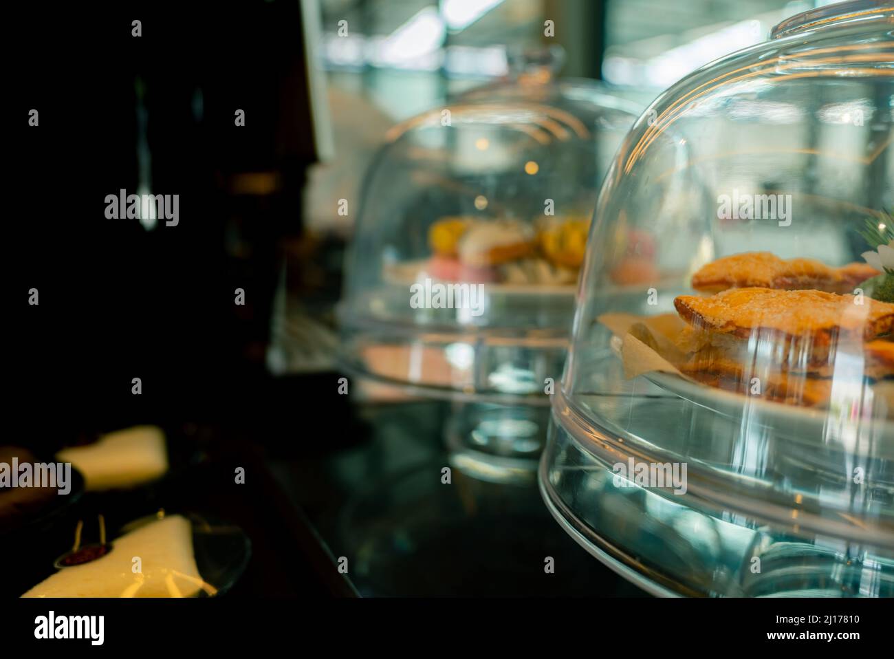 Pastry in cake glass stand display with cover dome in coffee shop or ...