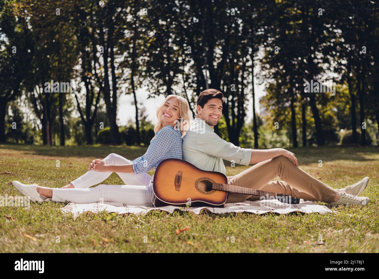 Portrait of two attractive cheery couple playing guitar pastime ...