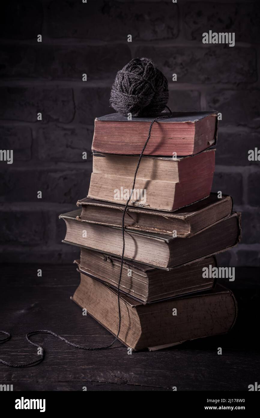 Stack of old books with ball of wool in vintage style Stock Photo - Alamy