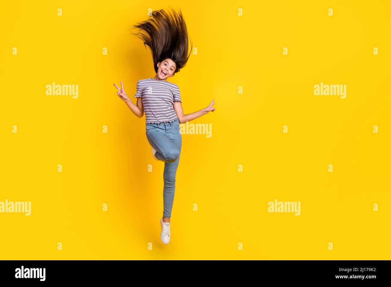Full length photo of young excited girl jump show fingers peace v ...
