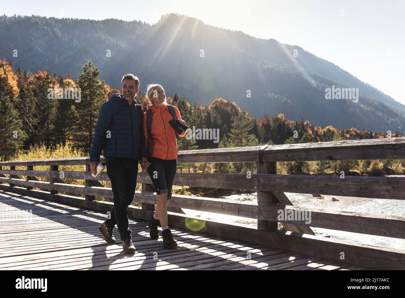 Austria, Alps, happy couple on a hiking trip crossing a bridge Stock ...