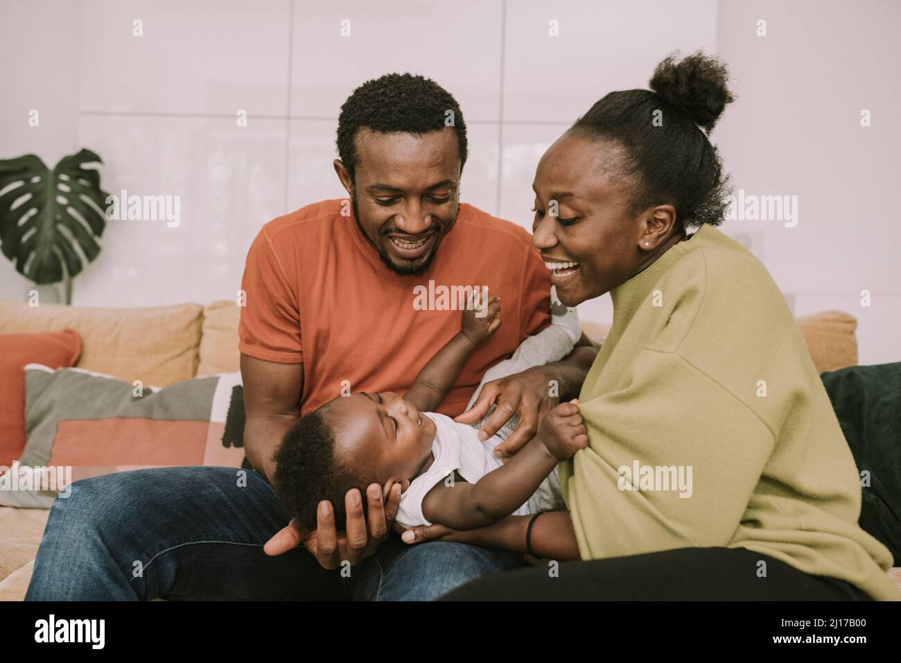 Happy parents tickling baby boy at home Stock Photo - Alamy