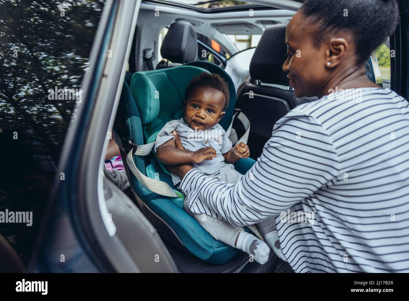 Mother lifting baby boy out of car Stock Photo - Alamy