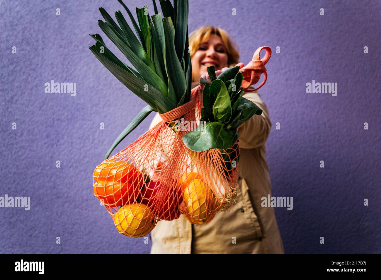 Woman showing reusable bag of vegetables Stock Photo - Alamy