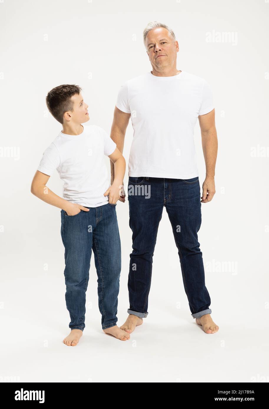 Boy with father standing against white background at studio Stock Photo ...