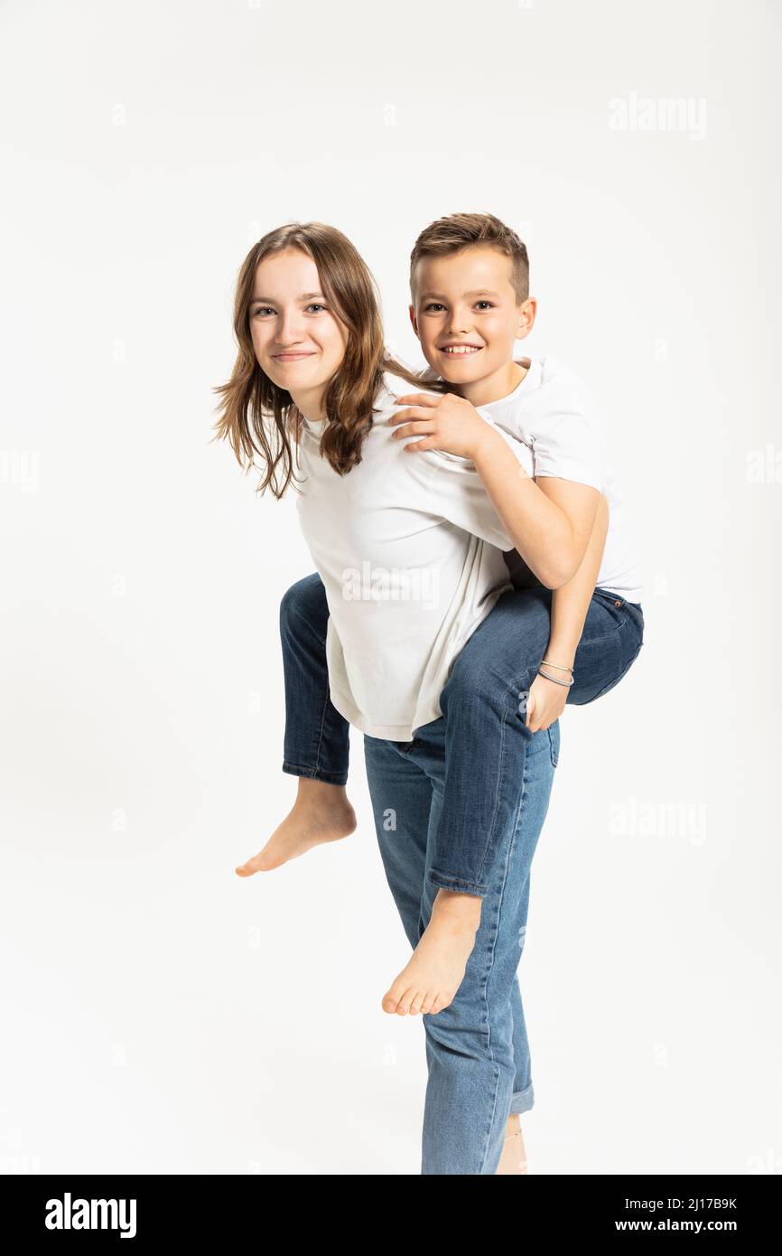 Sister giving brother piggyback ride in studio Stock Photo - Alamy