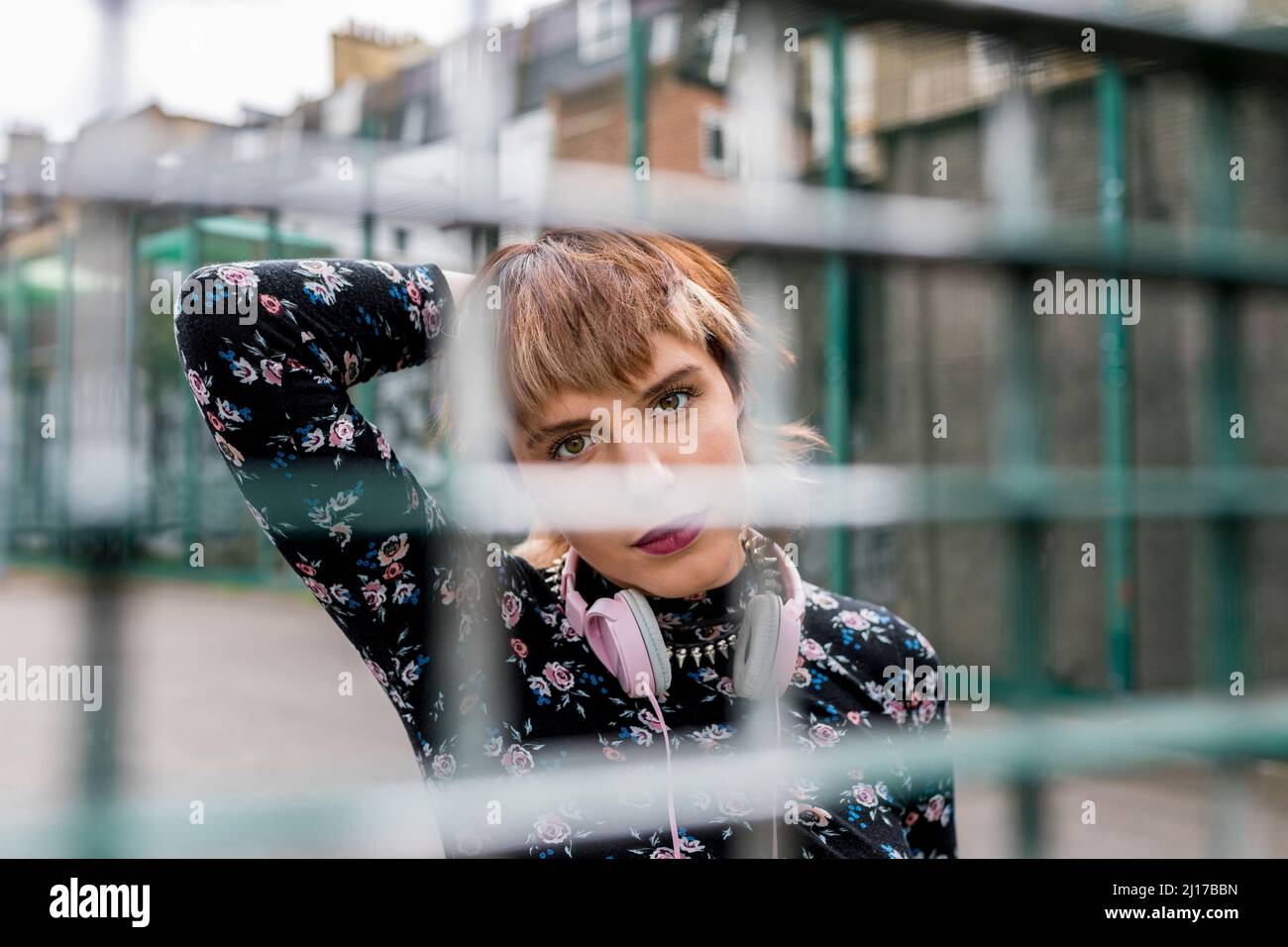 Young woman seen through fence Stock Photo - Alamy