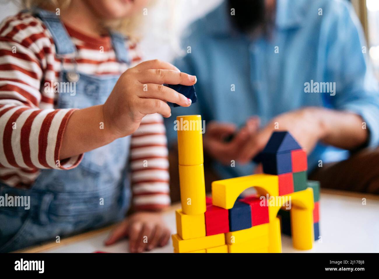 Boy building house with toy blocks by father at home Stock Photo - Alamy