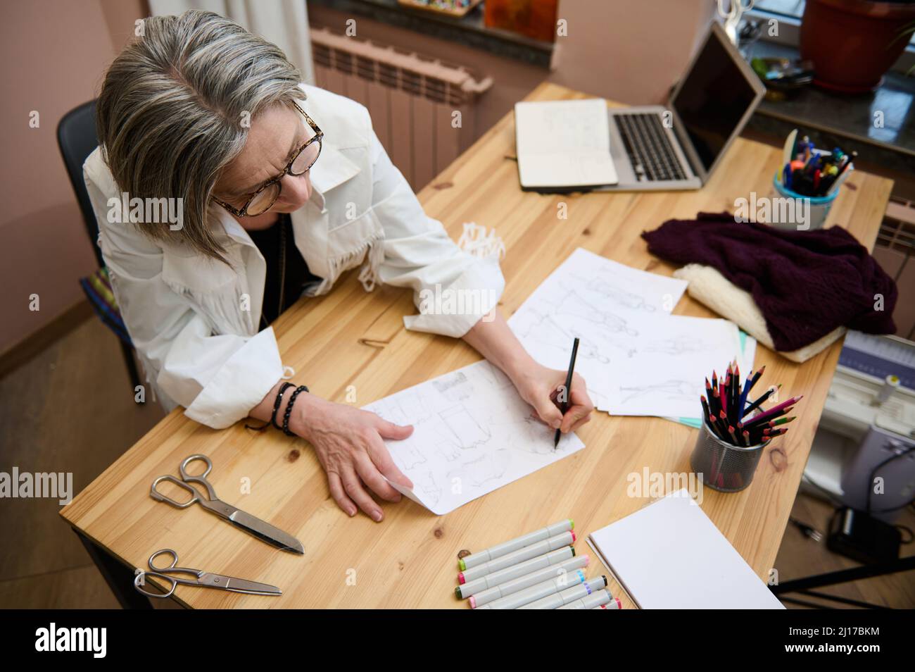 Overhead view of a senior female fashion designer tailor dressmaker ...