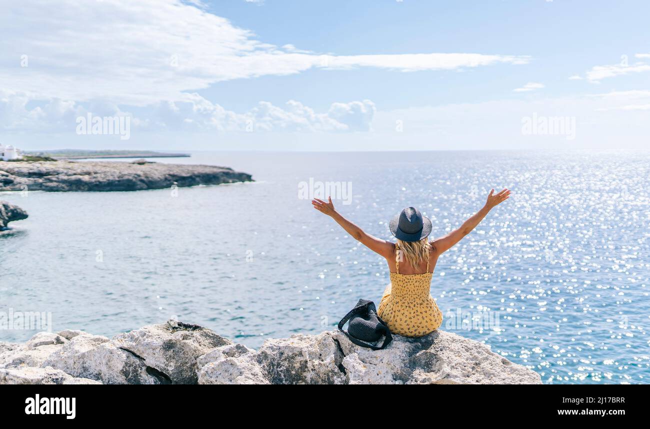 Woman sitting on rock arms hi-res stock photography and images - Alamy
