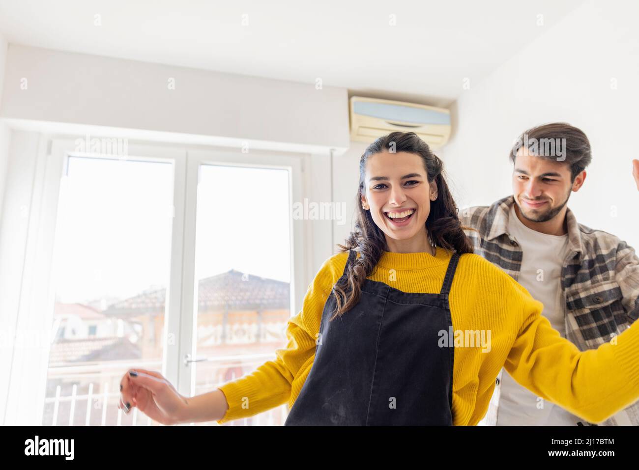 Cheerful girlfriend dancing with boyfriend at new home Stock Photo - Alamy