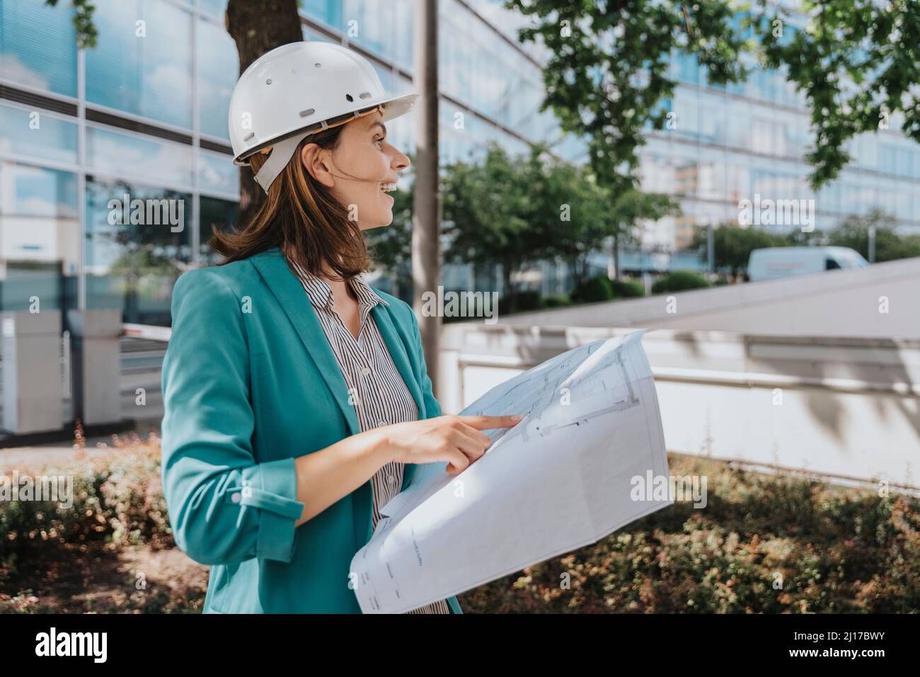 Architect wearing smart casuals holding construction plan Stock Photo ...