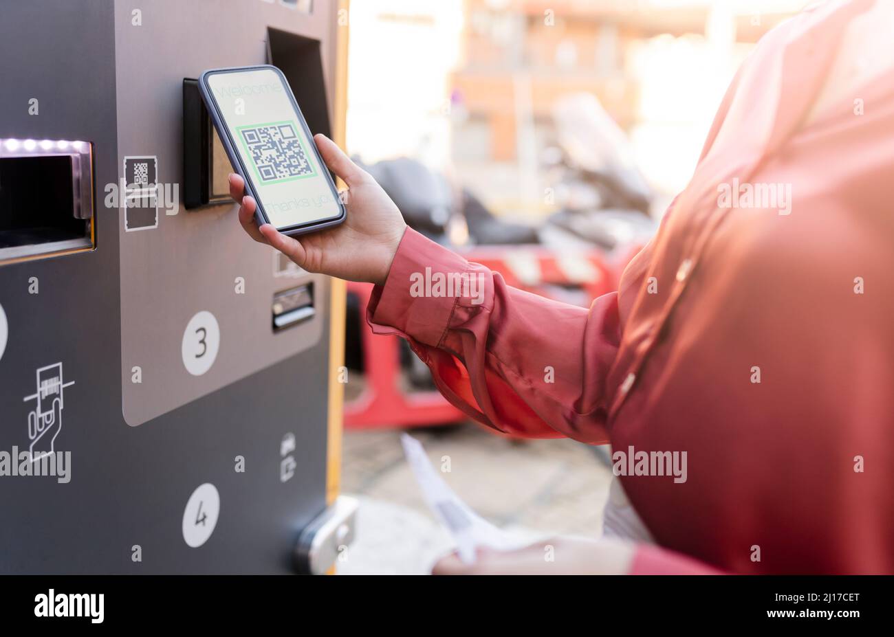 Woman scanning QR code on ticket machine at station Stock Photo - Alamy