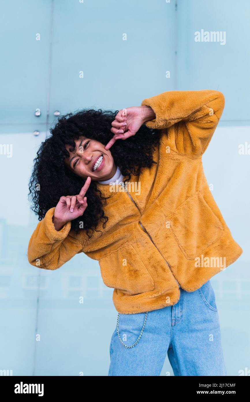 Cheerful woman pointing on cheeks Stock Photo - Alamy
