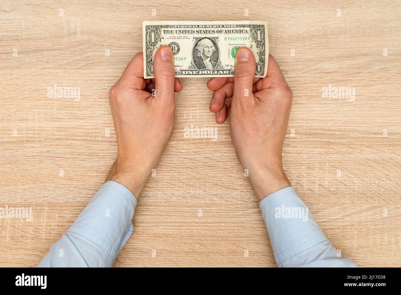 One dollar banknote in male hands on a table background Stock Photo - Alamy