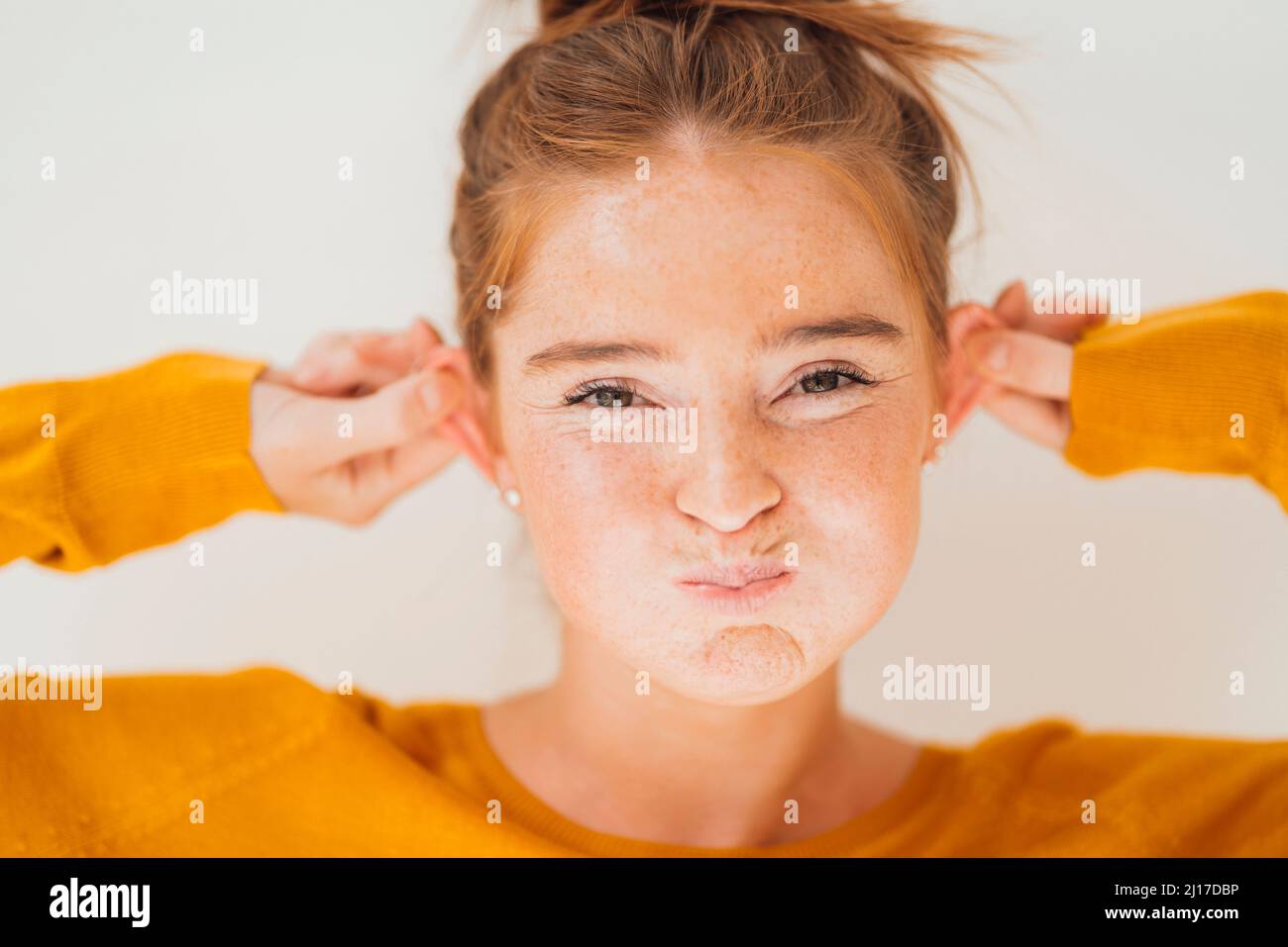 Playful woman pulling ears at studio Stock Photo - Alamy